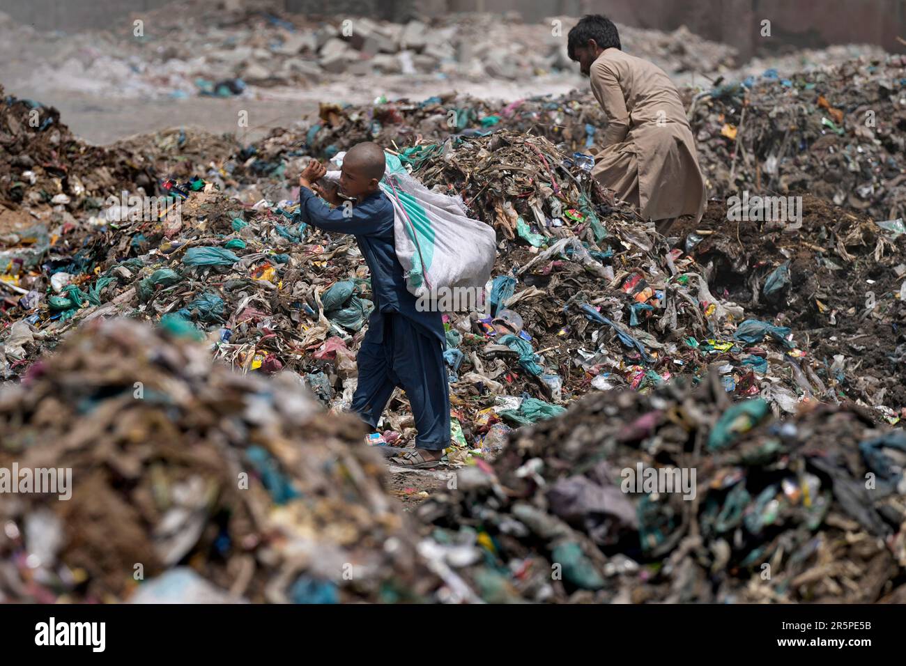 Scavengers collect usable and recyclable material at garbage dump, to ...