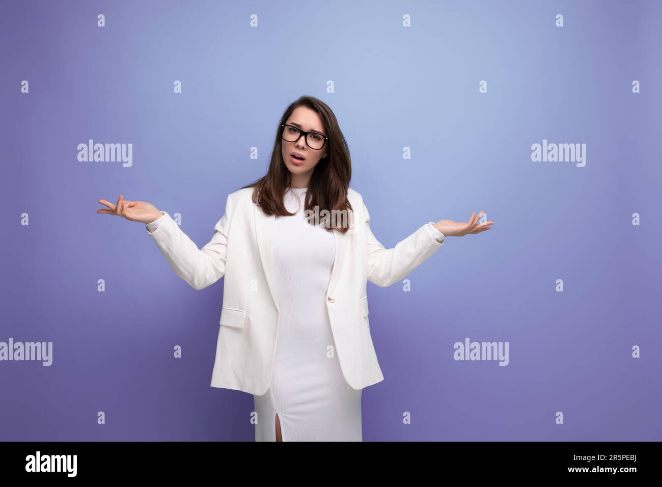 suspicious young woman in business attire looks at camera in studio ...