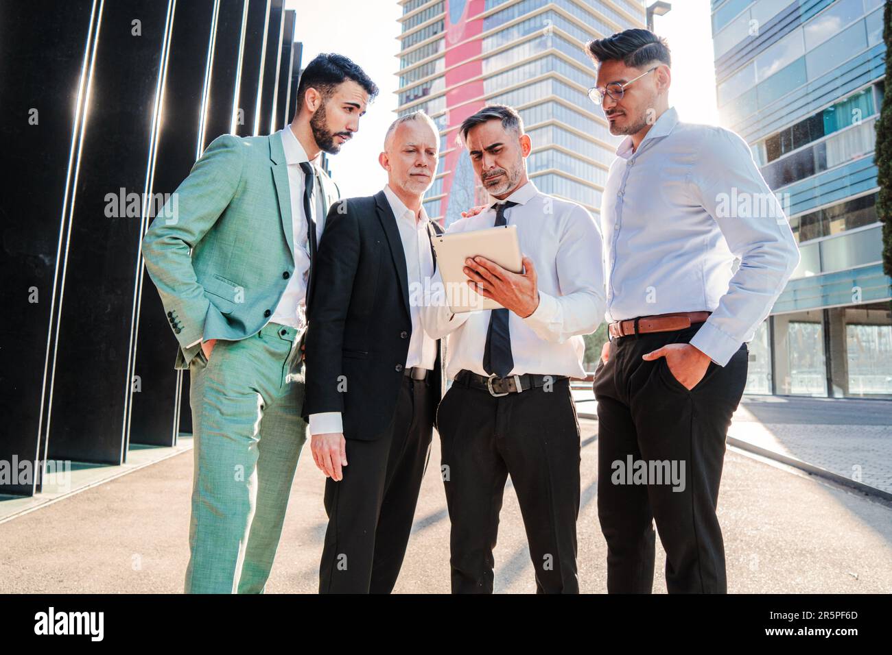 Serious group of five business men in formal wear checking a financial ...