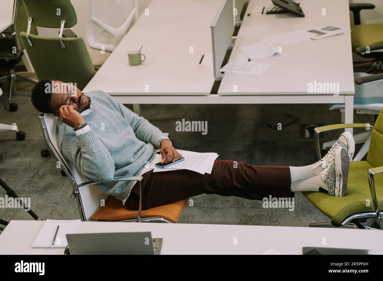 Sleeping at the office. Young black male is tired after hard daily ...