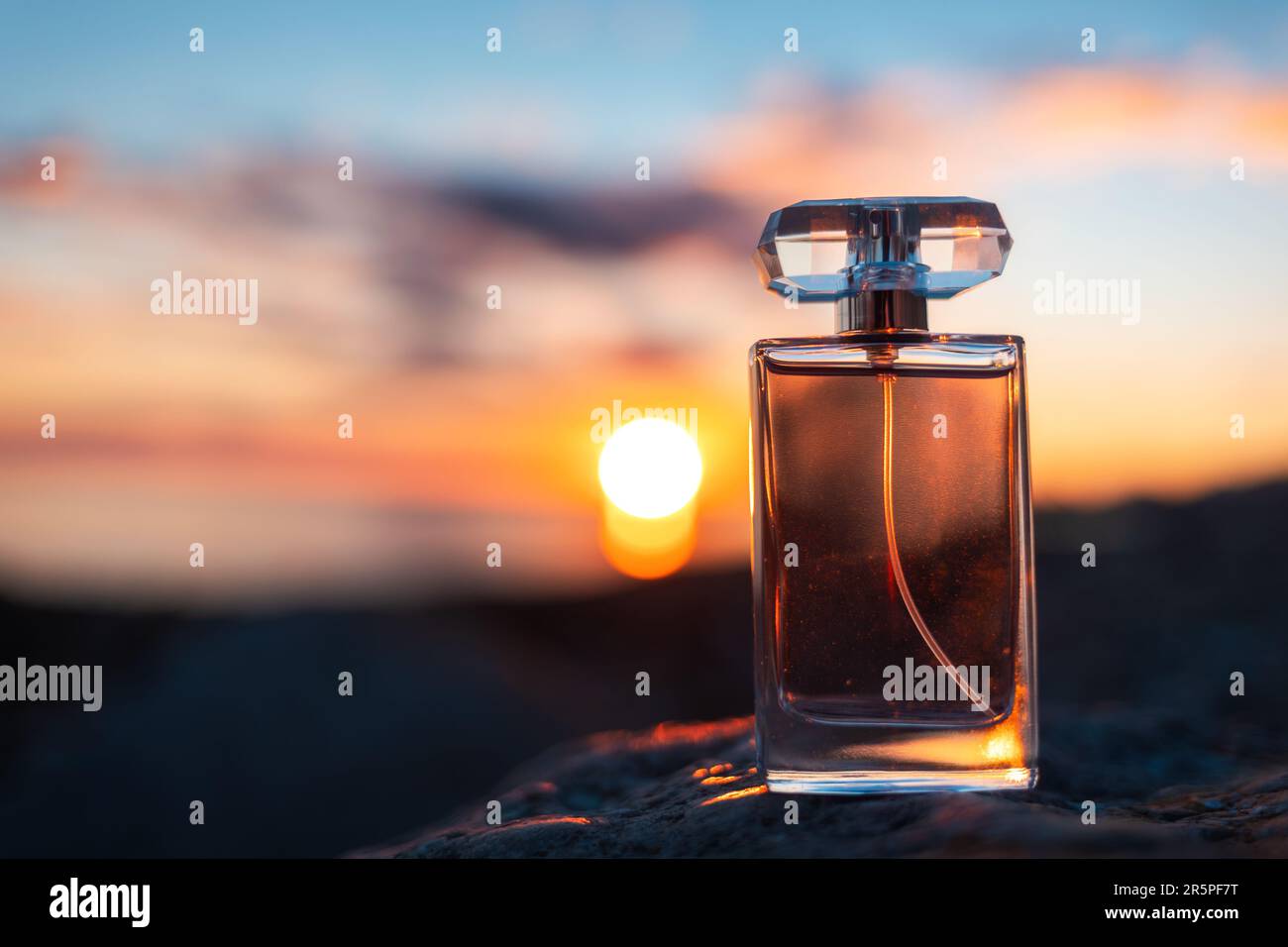 Cologne and perfumery. Close up of glass golden perfume bottle standing ...