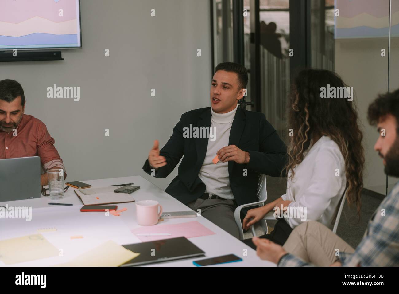 Close up of younger business man explaining something to his colleagues ...