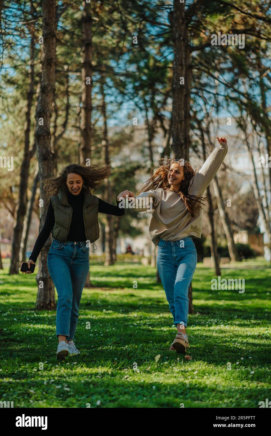 Front view shot of two lovely girls dancing while walking. They are ...