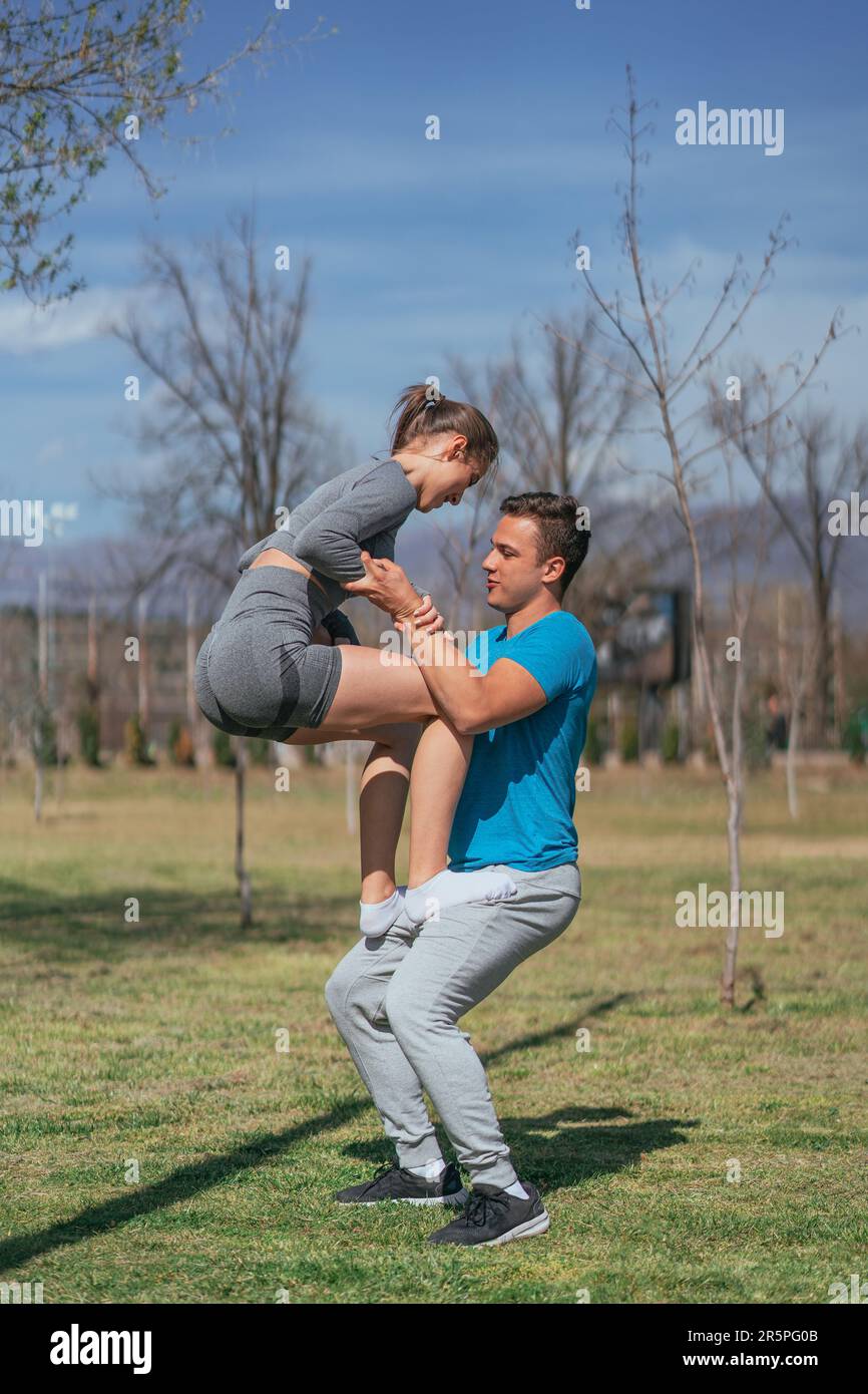 Good looking, strong man holding his girlfriend while she is standing ...