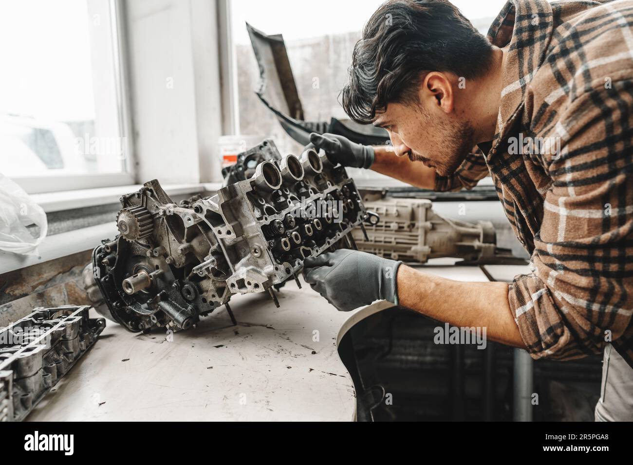 Workman disassembling car engine at the working table of the car service garage Stock Photo - Alamy