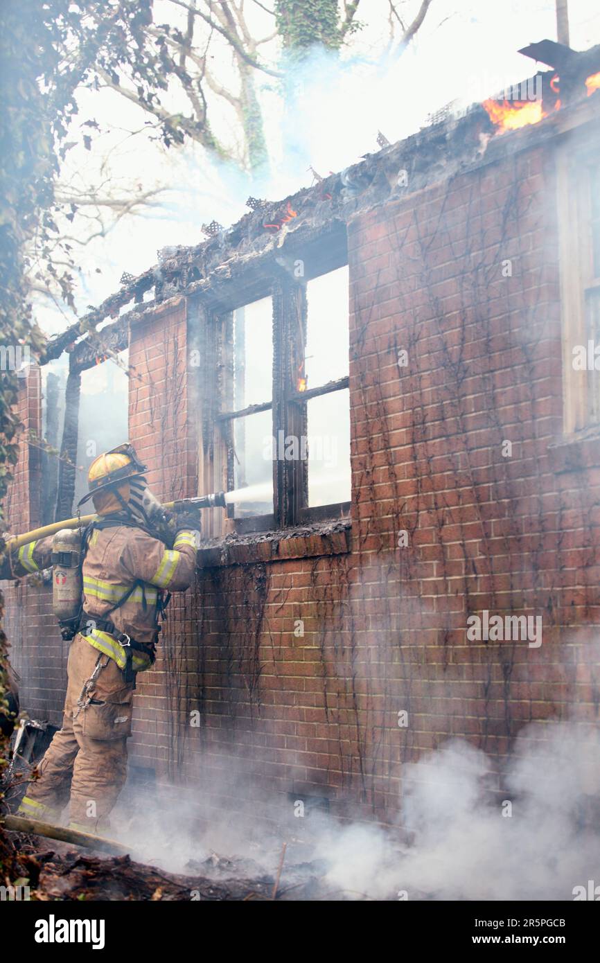 Firefighters extinguishing house fire Stock Photo - Alamy