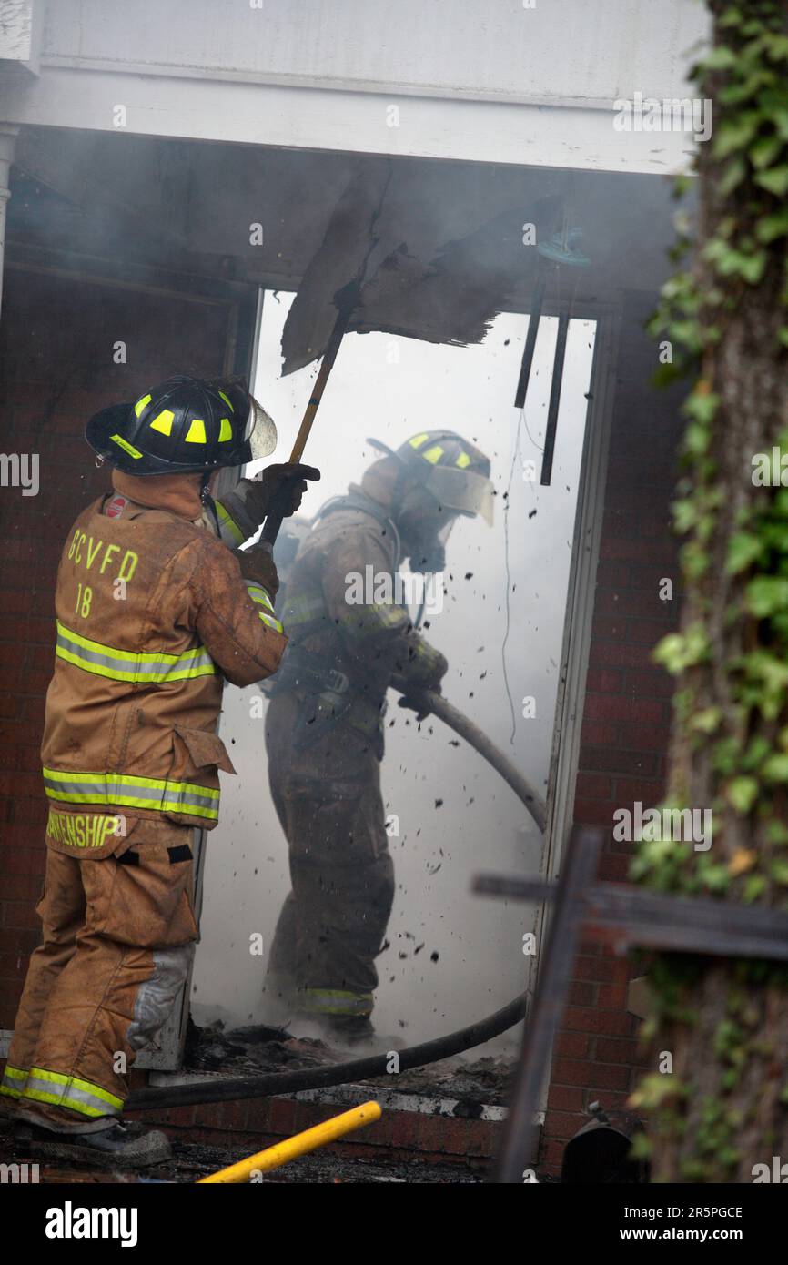 Firefighters extinguishing house fire Stock Photo - Alamy