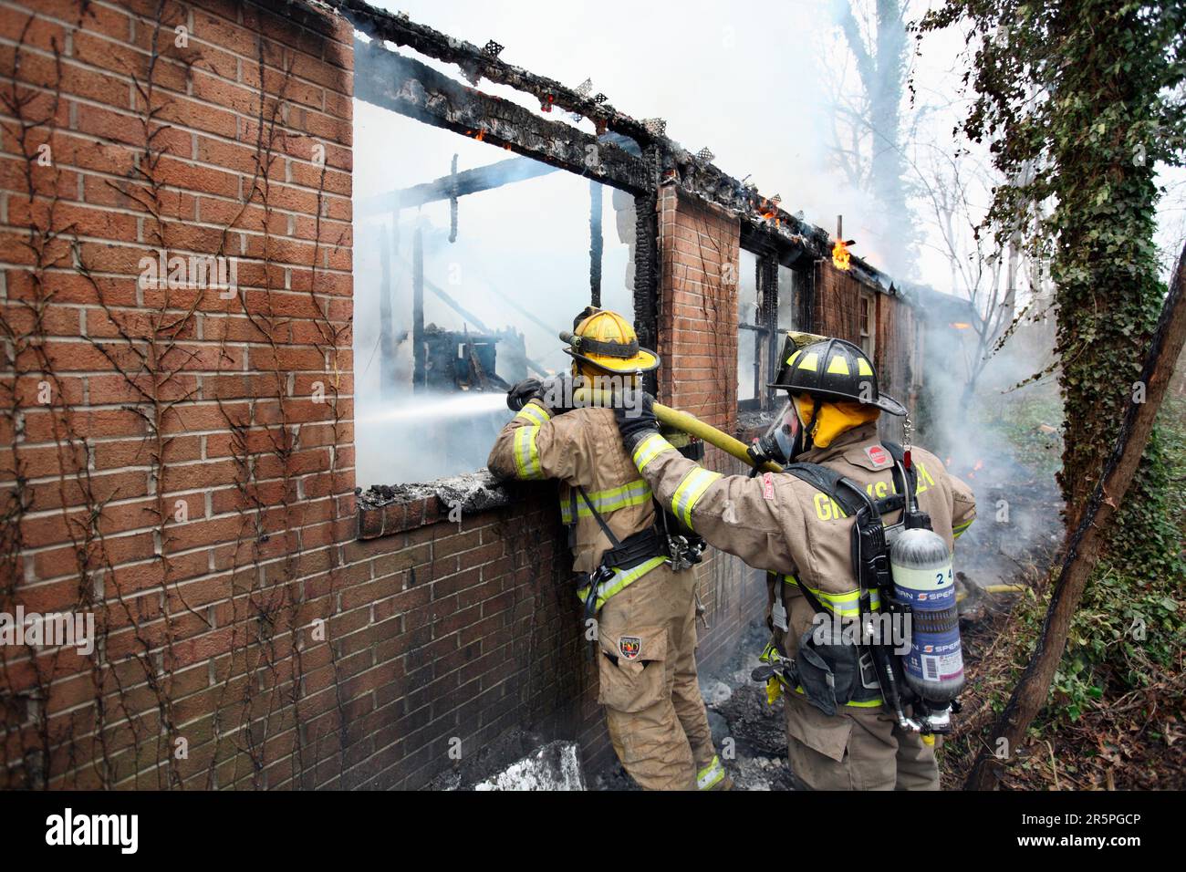 Firefighters extinguishing house fire Stock Photo - Alamy