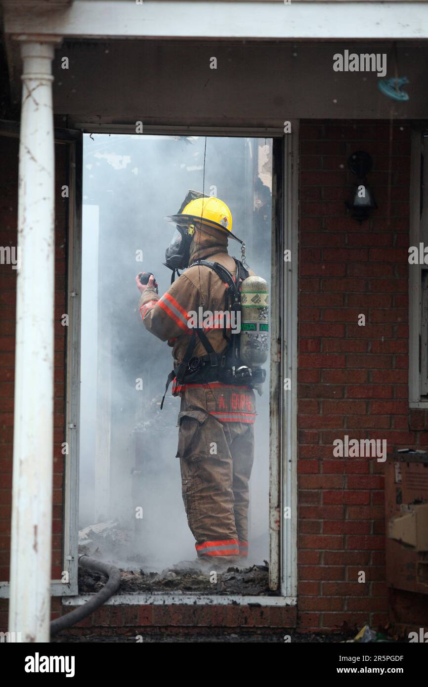 Firefighters extinguishing house fire Stock Photo - Alamy
