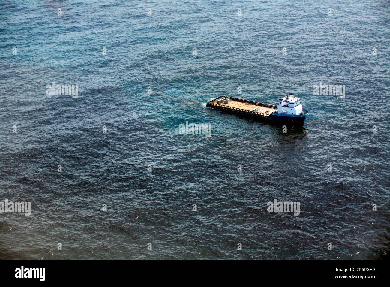 A ship floats in oily water near the Deepwater Horizon sunken rig site ...