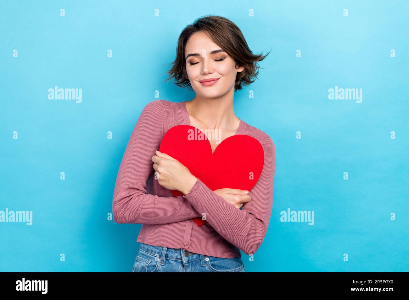 Photo of cute lady hold close to chest hug big red paper heart charity ...