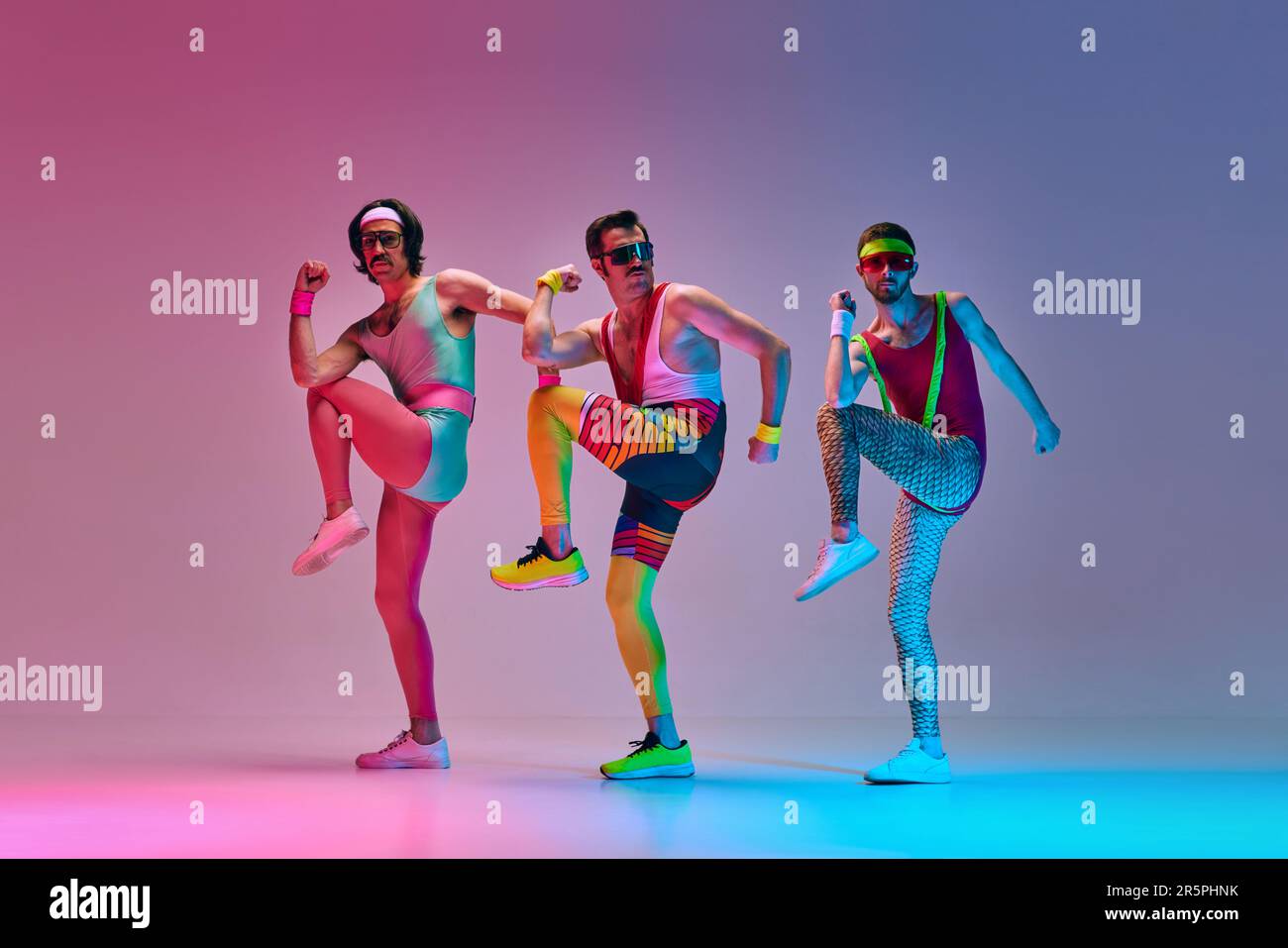 Sport show. Three funny men in colorful sportswear doing aerobics ...