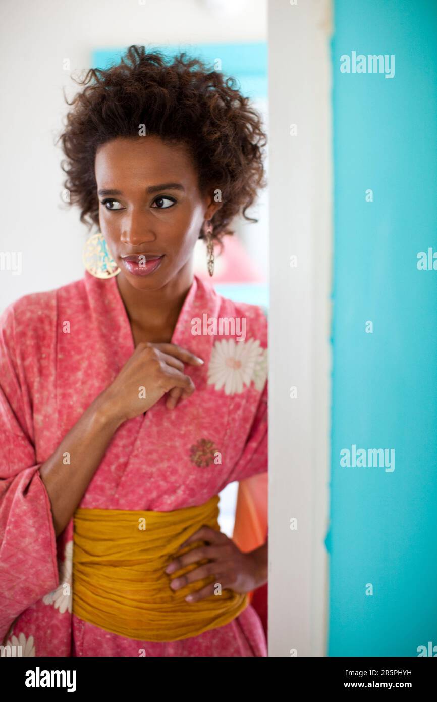 A model photographed during a lifestyle shoot standing in a doorway ...