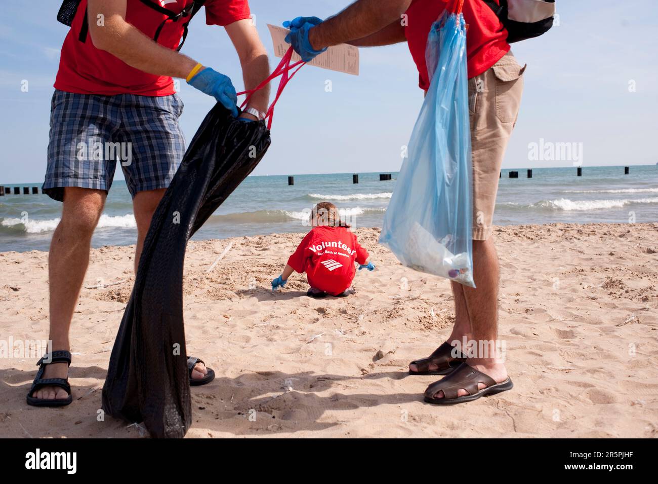 Volunteers from Bank of America pick up trash on the beach during the ...