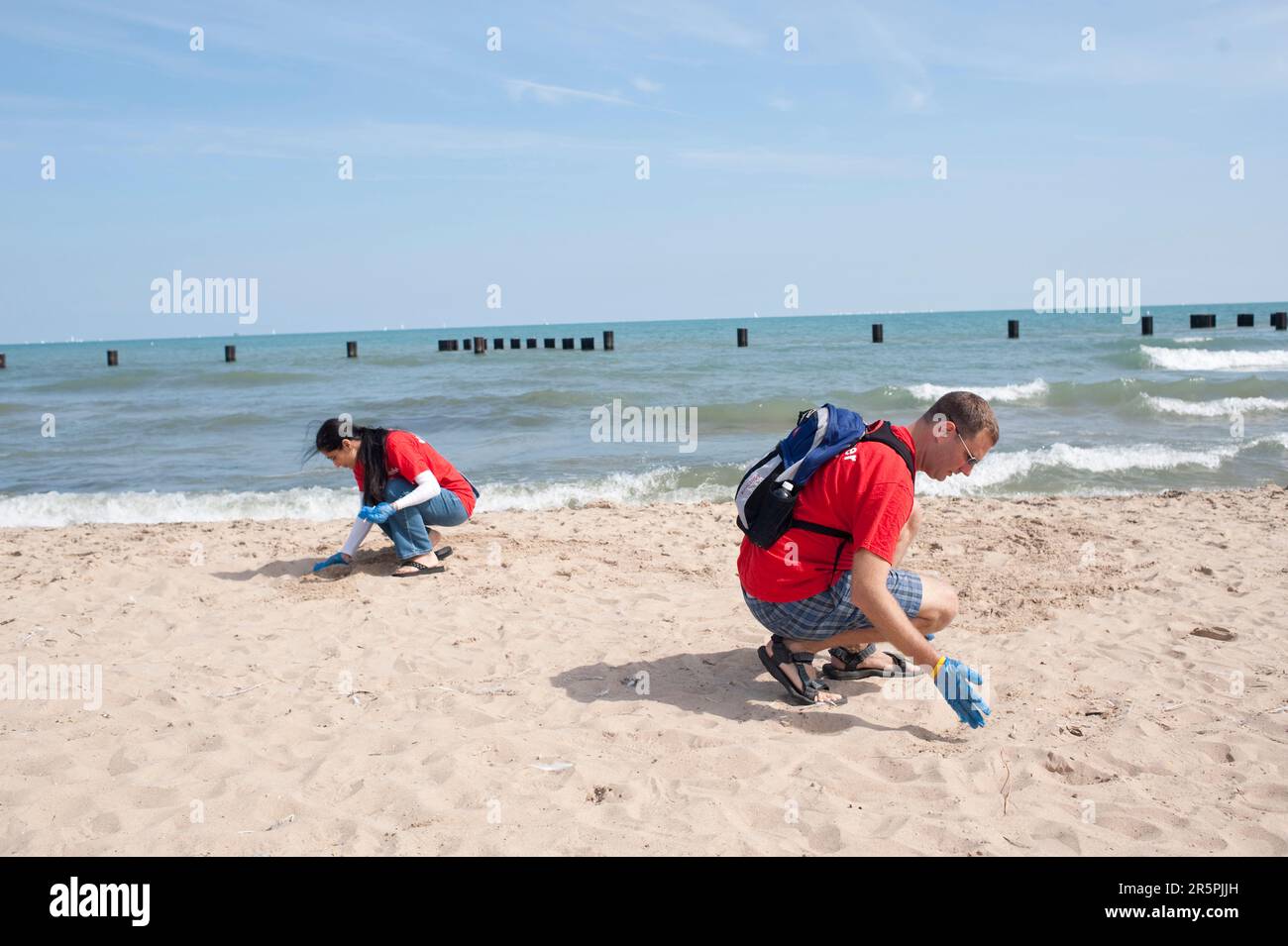 Volunteers from Bank of America pick up trash on the beach during the ...