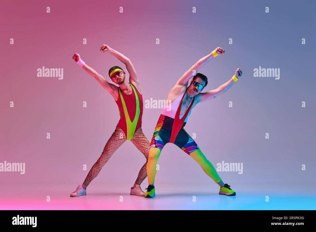 Young men, fitness coach in colorful sportswear stretching, training ...