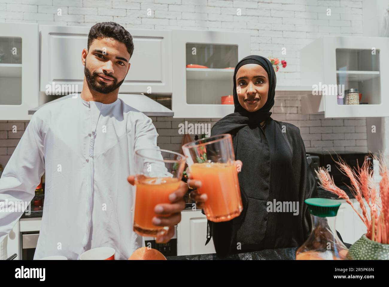 Happy middle-eastern couple wearing traditional arab clothing at home ...