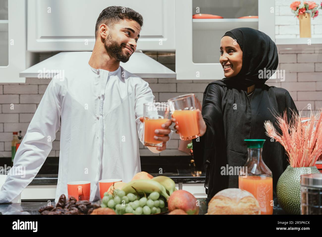 Happy middle-eastern couple wearing traditional arab clothing at home ...