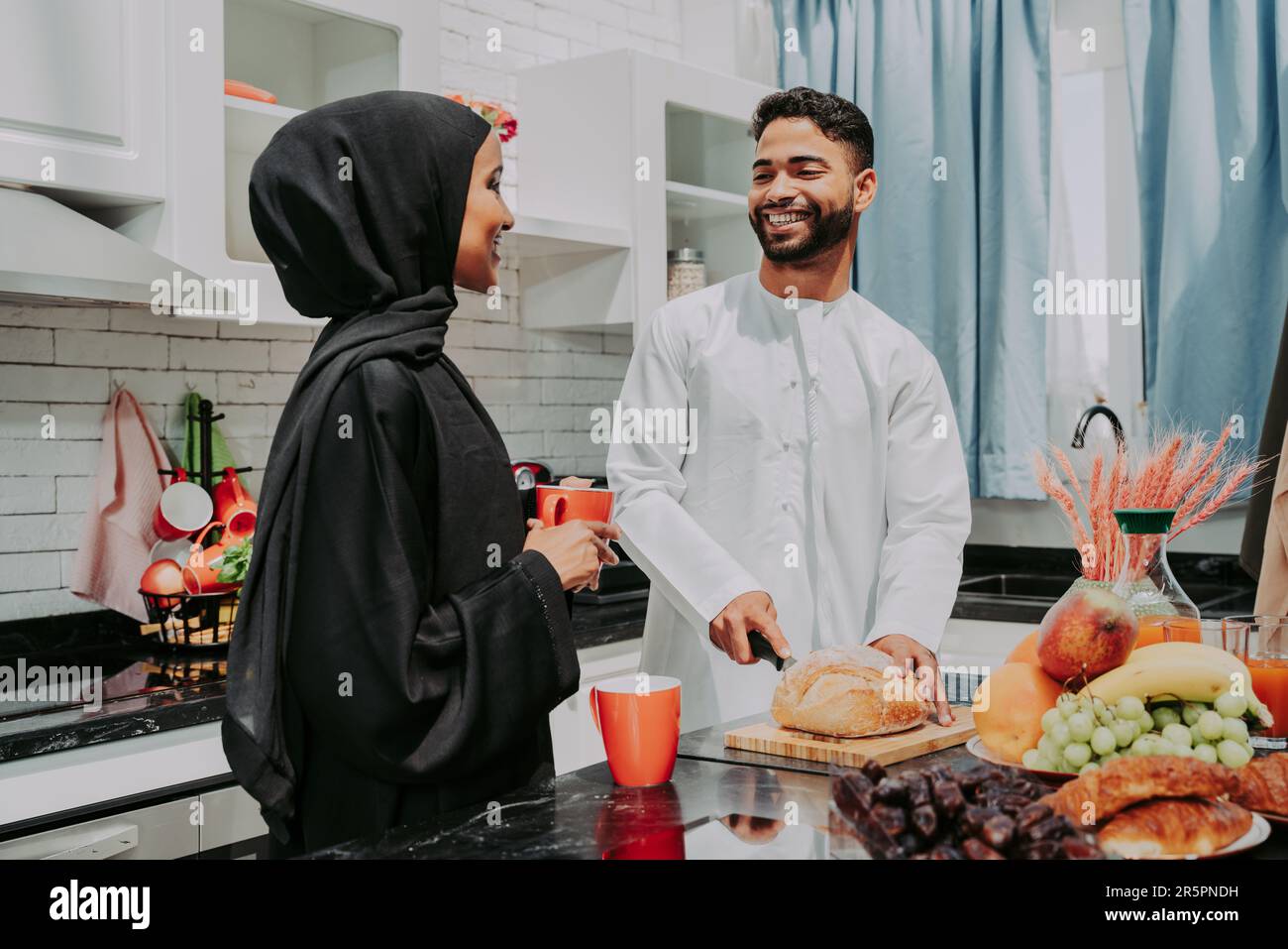 Happy middle-eastern couple wearing traditional arab clothing at home ...