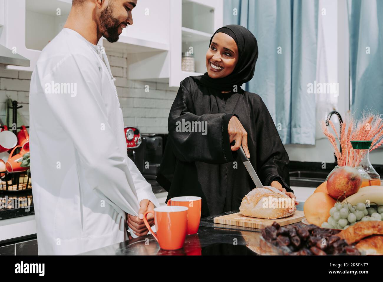 Happy middle-eastern couple wearing traditional arab clothing at home ...