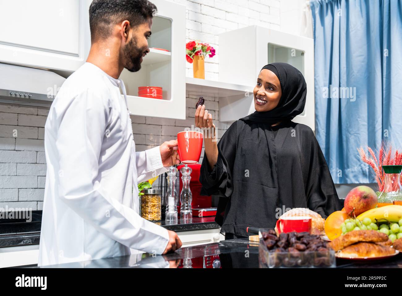 Happy middle-eastern couple wearing traditional arab clothing at home ...