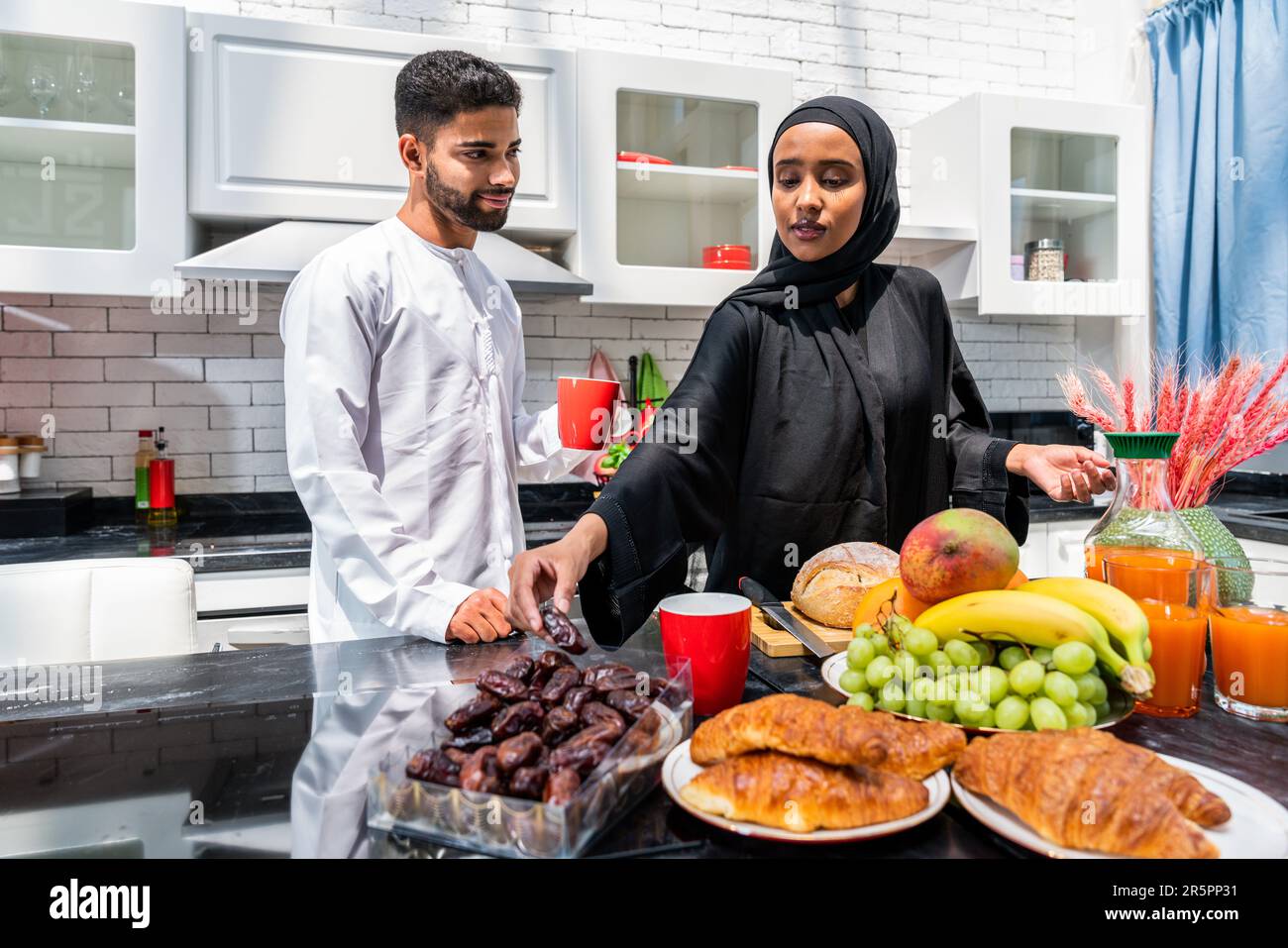 Happy middle-eastern couple wearing traditional arab clothing at home ...