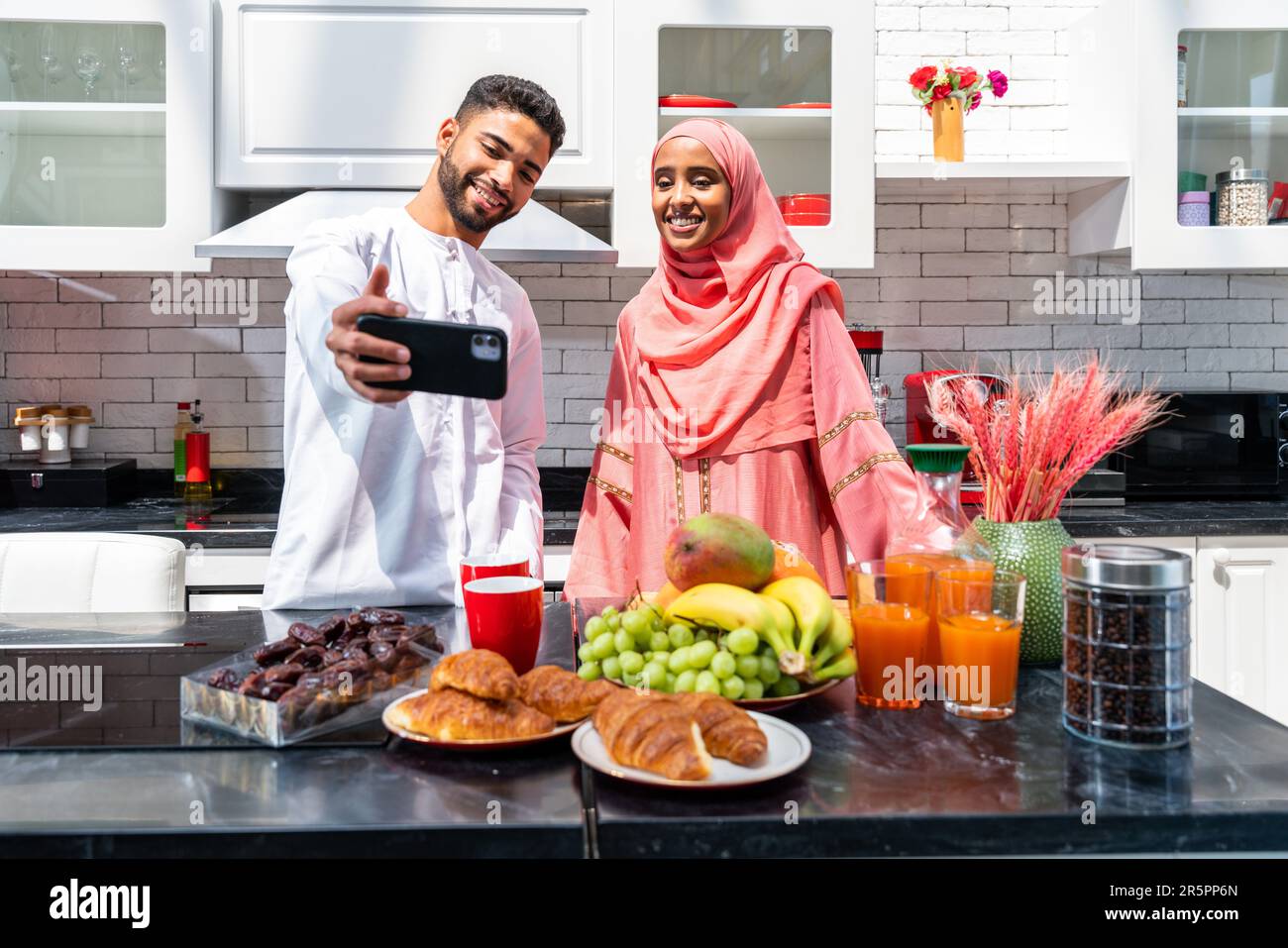 Happy middle-eastern couple wearing traditional arab clothing at home ...