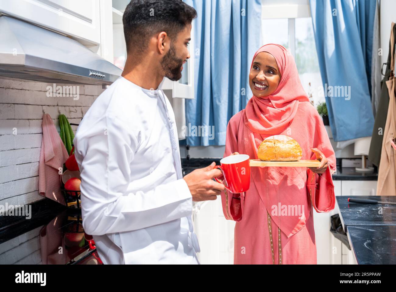 Happy middle-eastern couple wearing traditional arab clothing at home ...