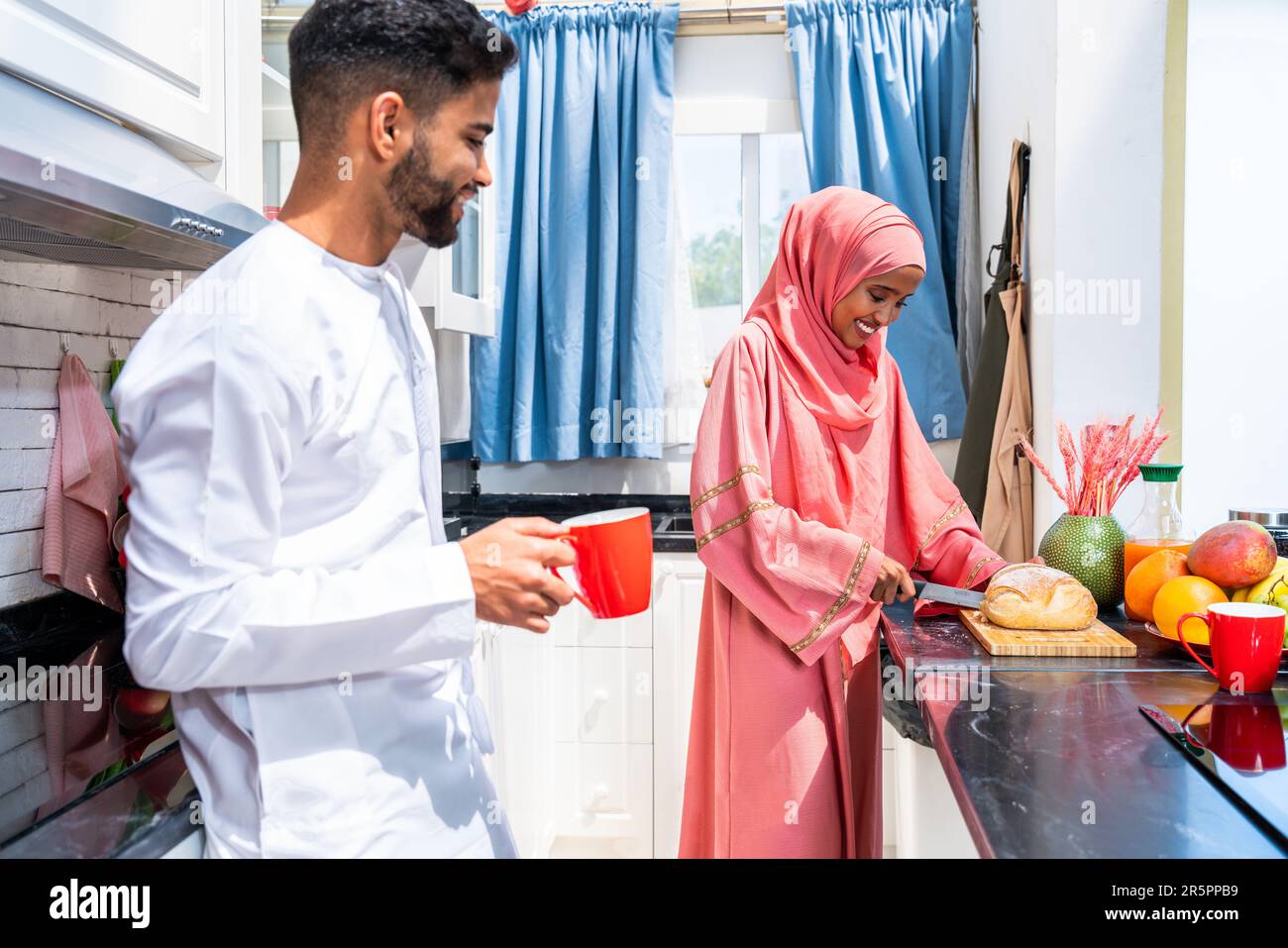 Happy middle-eastern couple wearing traditional arab clothing at home ...