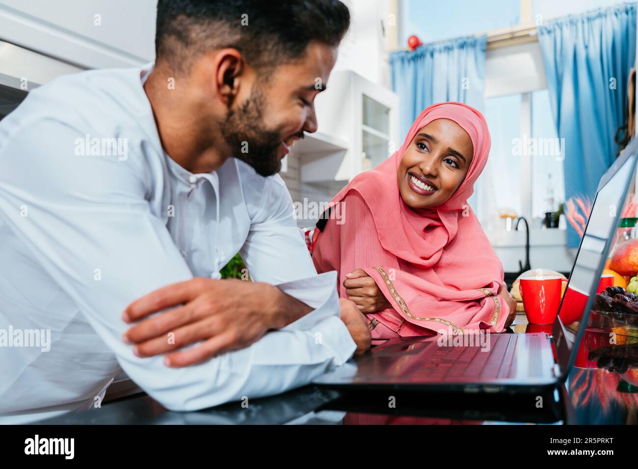 Happy middle-eastern couple wearing traditional arab clothing at home ...