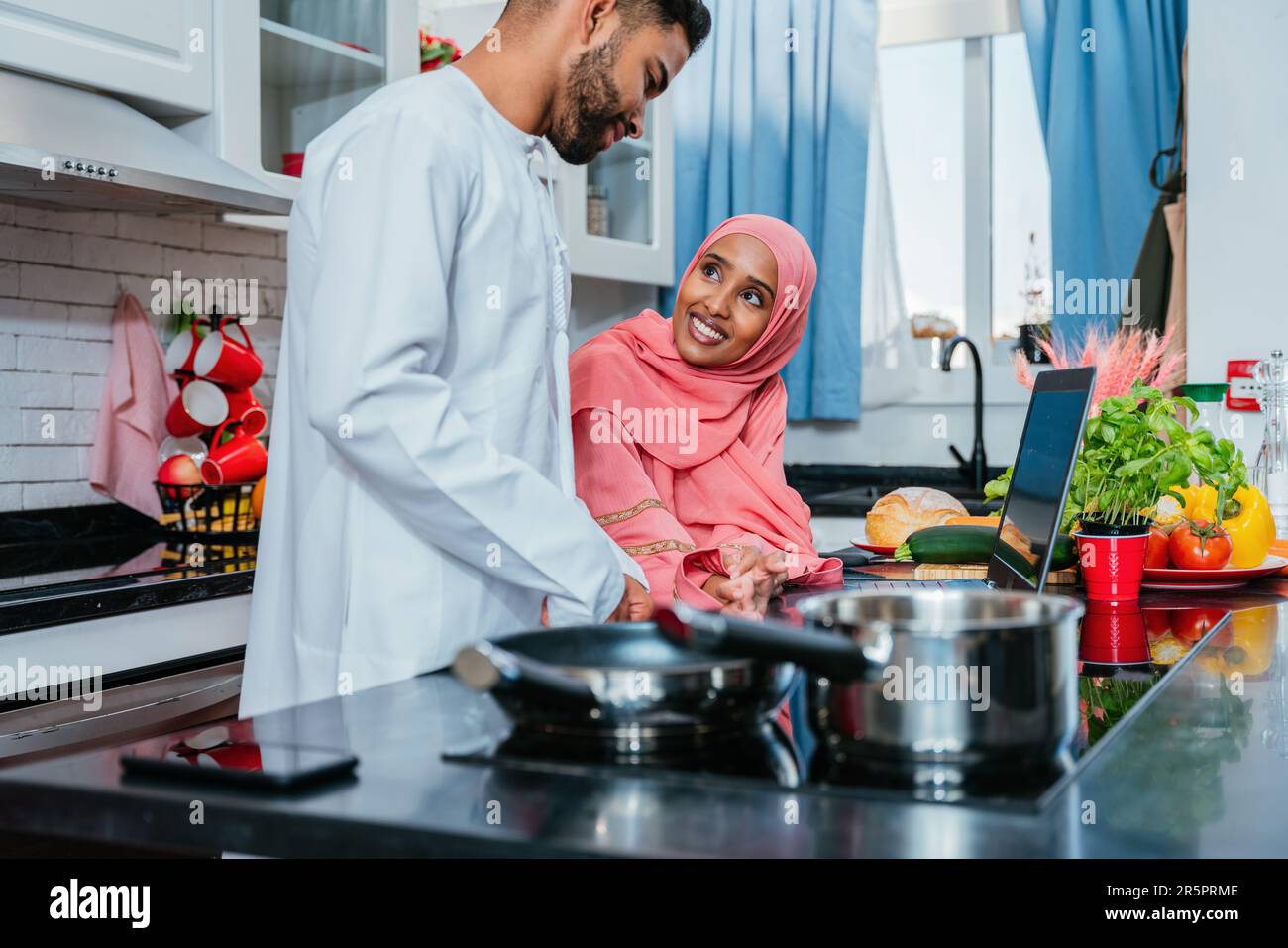 Happy middle-eastern couple wearing traditional arab clothing at home ...