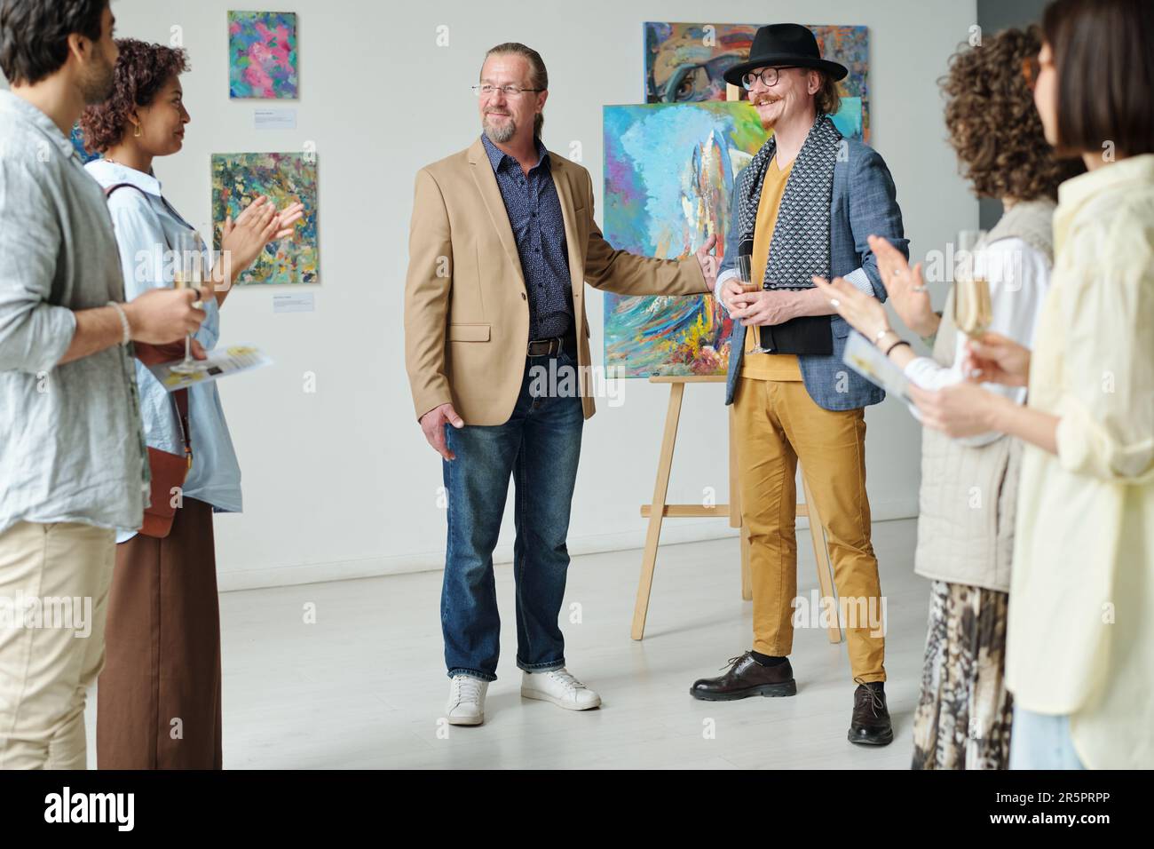 Modern artist and gallery owner making presentation of painting to ...