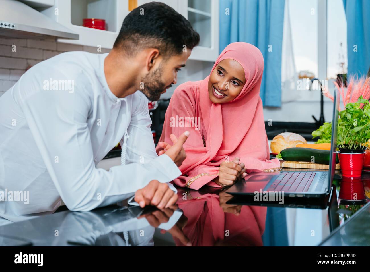 Happy middle-eastern couple wearing traditional arab clothing at home ...