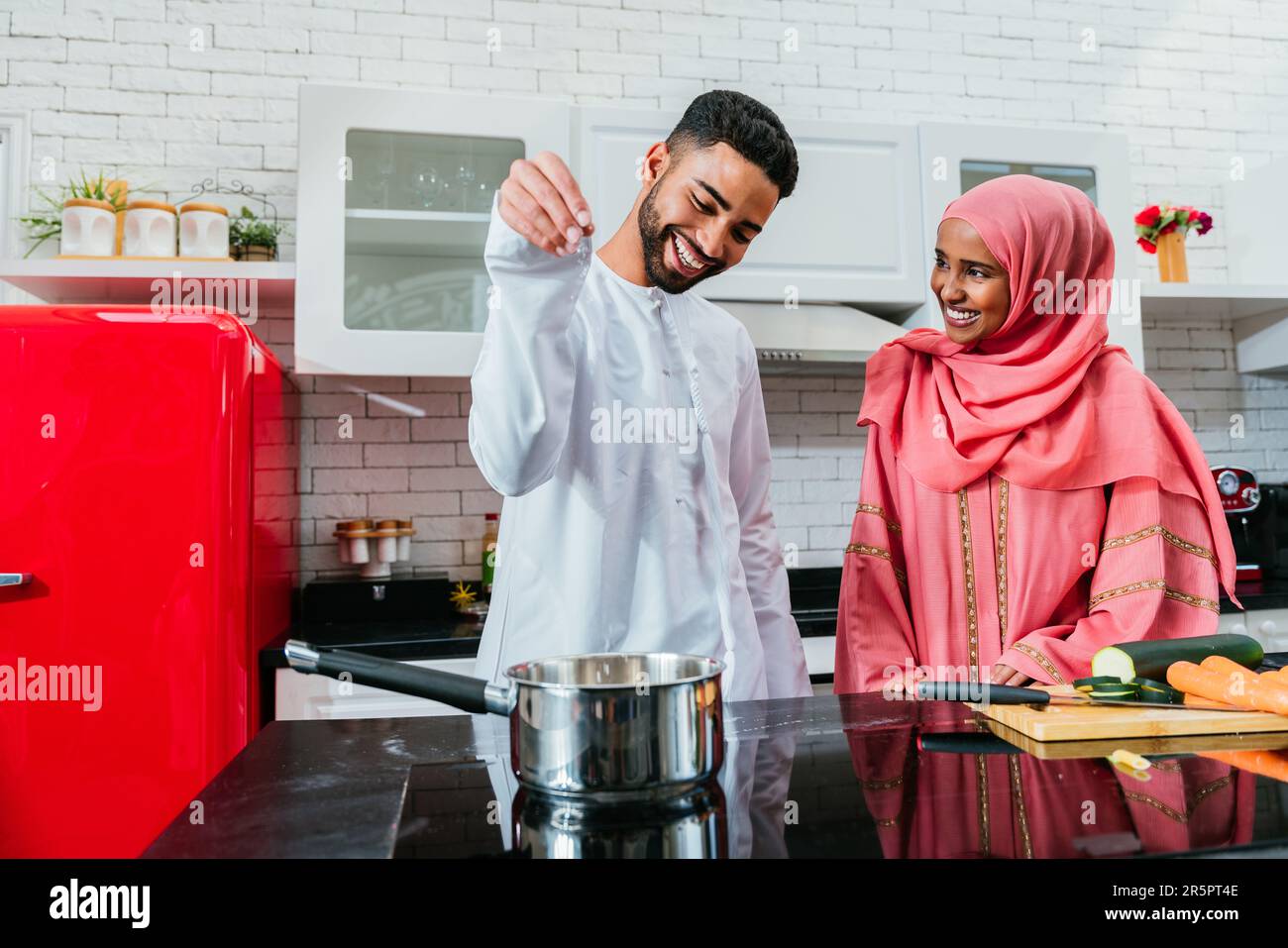 Happy middle-eastern couple wearing traditional arab clothing at home ...