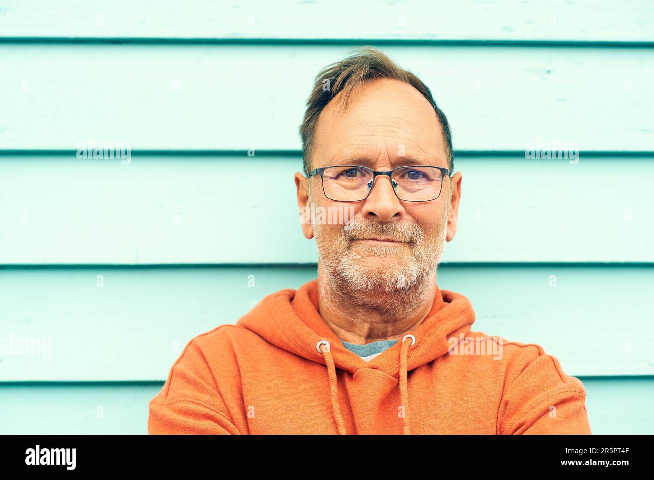 Outdoor portrait of handsome middle age man posing against turquoise ...