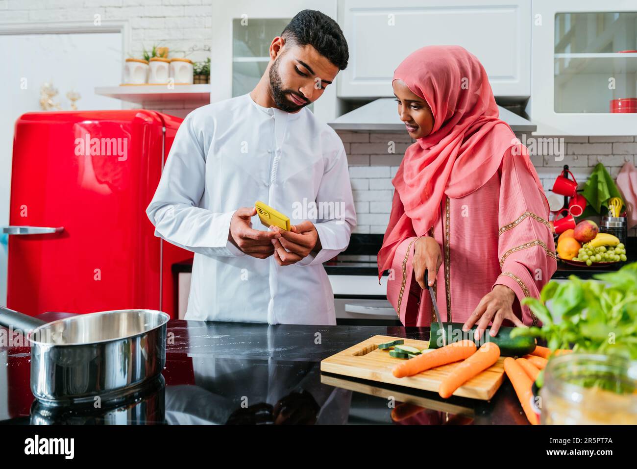 Happy middle-eastern couple wearing traditional arab clothing at home ...