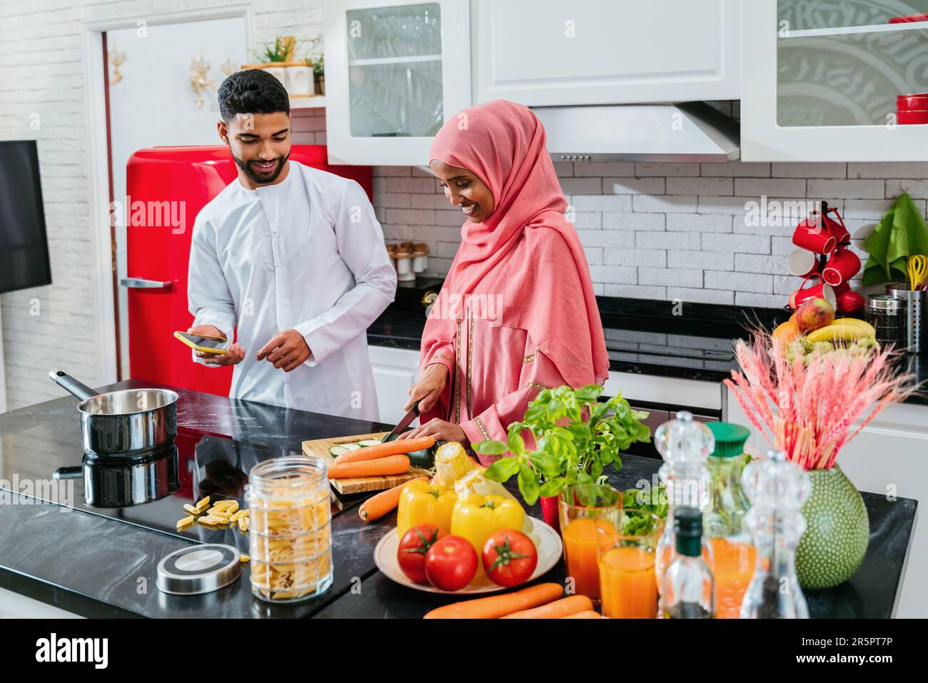 Happy middle-eastern couple wearing traditional arab clothing at home ...