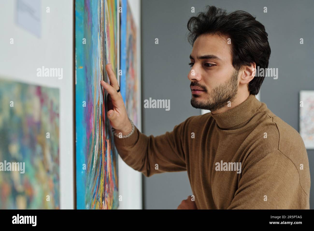 Art lover examining painting on the wall and enjoying modern art in art ...