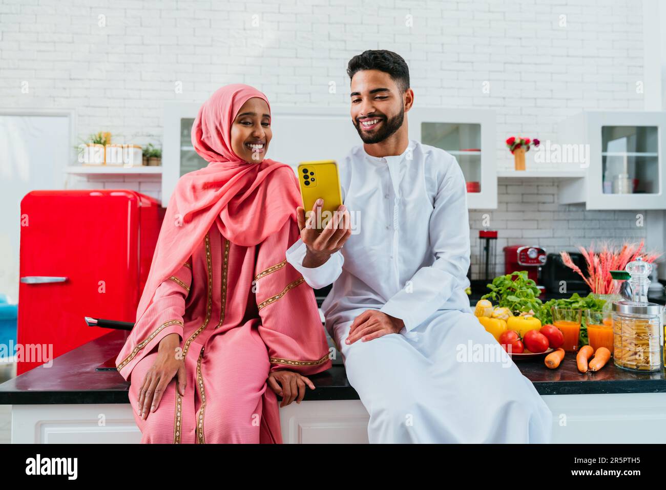Happy middle-eastern couple wearing traditional arab clothing at home ...