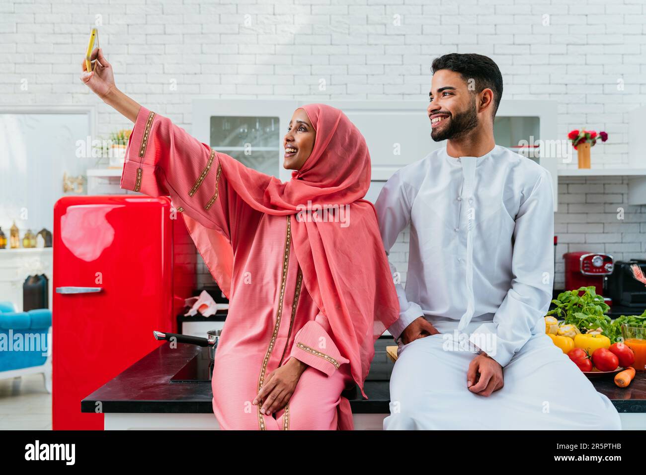 Happy middle-eastern couple wearing traditional arab clothing at home ...