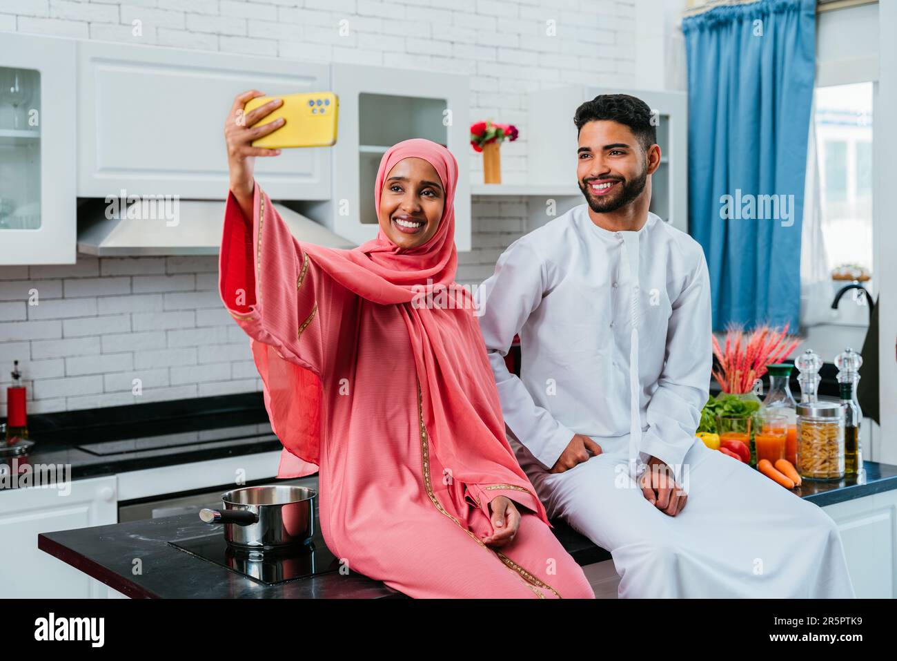 Happy middle-eastern couple wearing traditional arab clothing at home ...