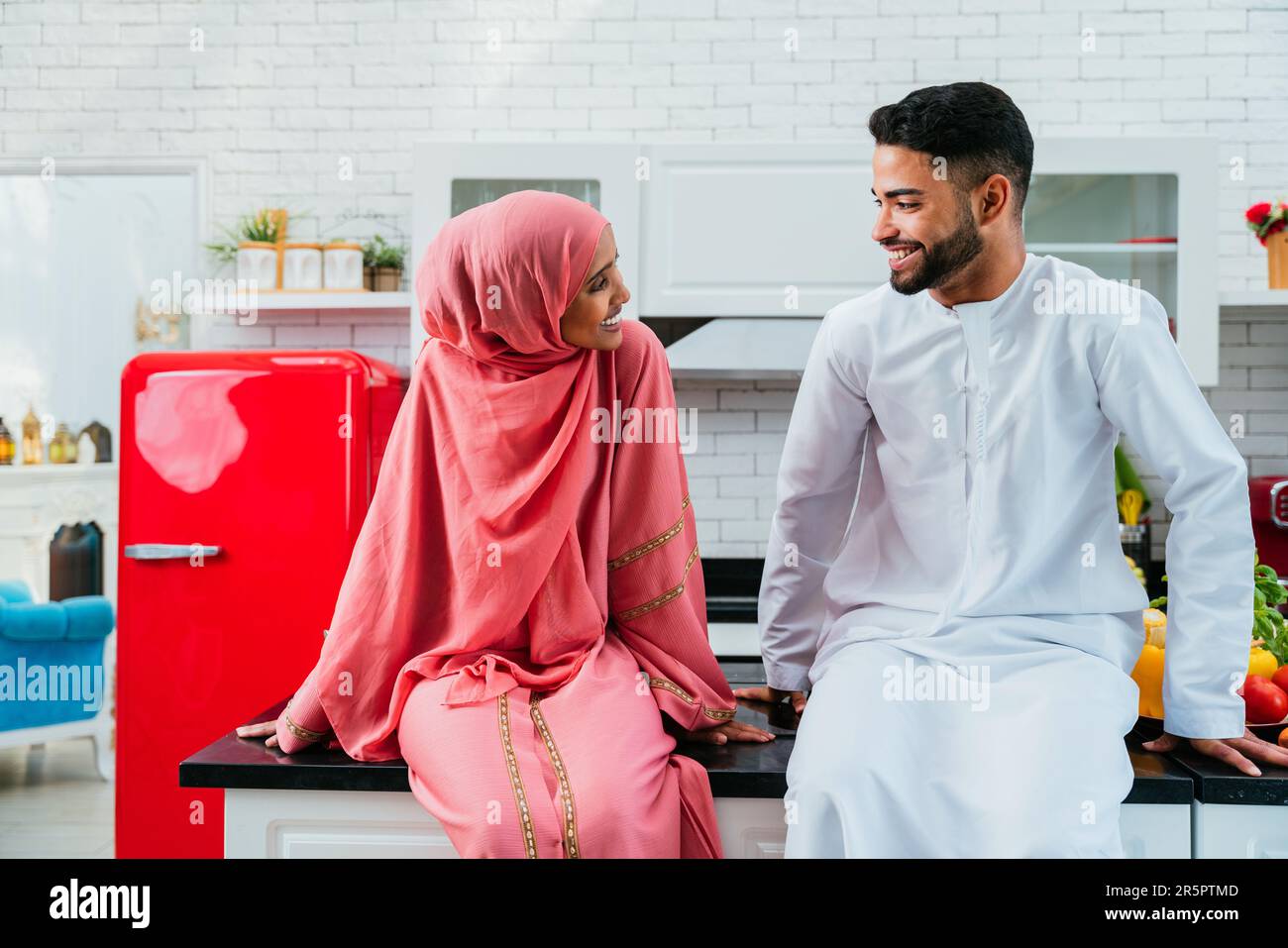 Happy middle-eastern couple wearing traditional arab clothing at home ...