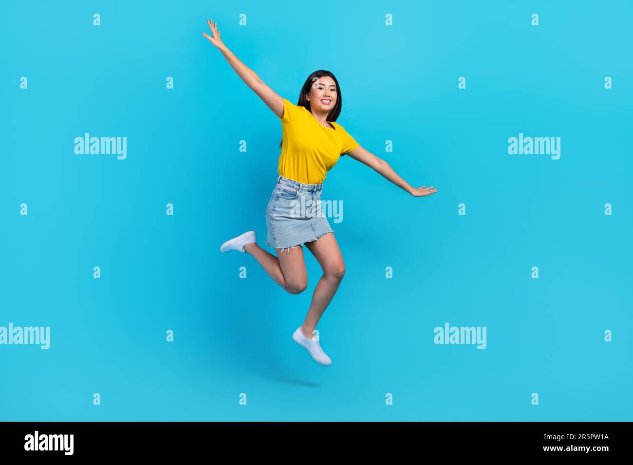 Full body portrait of active cheerful lady jumping arms wings flying ...