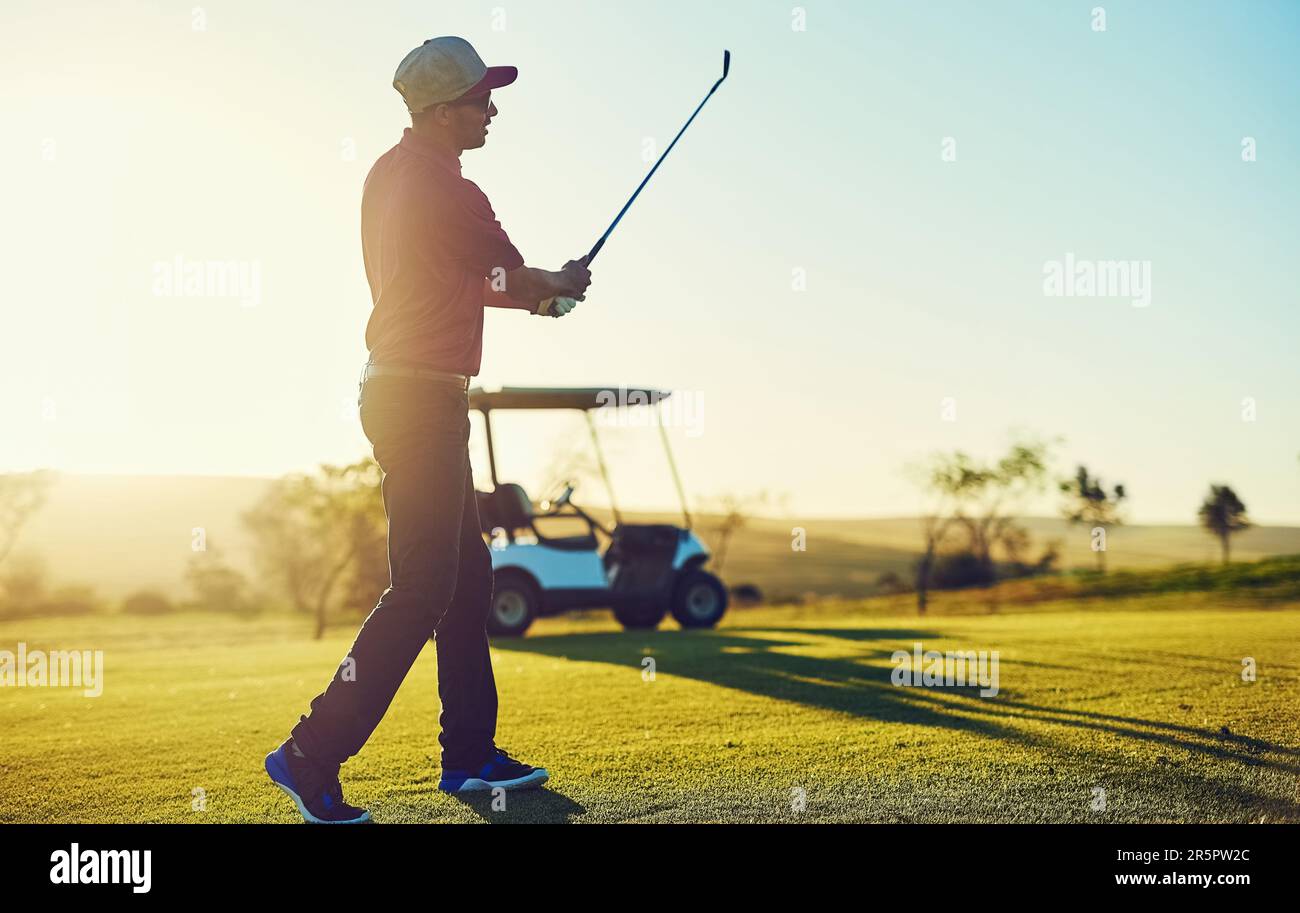 What a perfectly smooth swing. a young man playing golf Stock Photo - Alamy