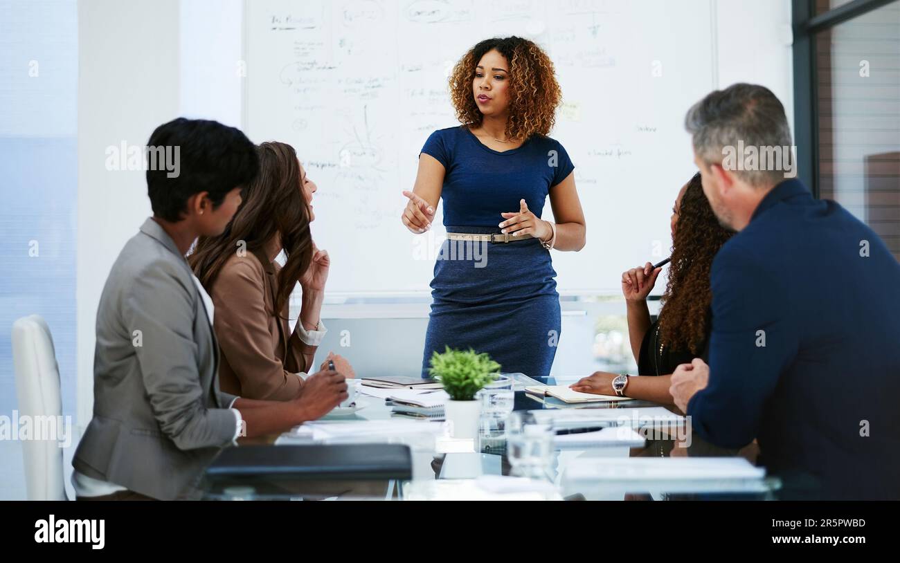 Addressing her colleagues. a young businesswoman giving a presentation ...