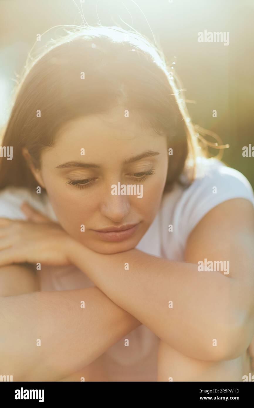 portrait of sad young woman with brunette long hair, in white polo ...