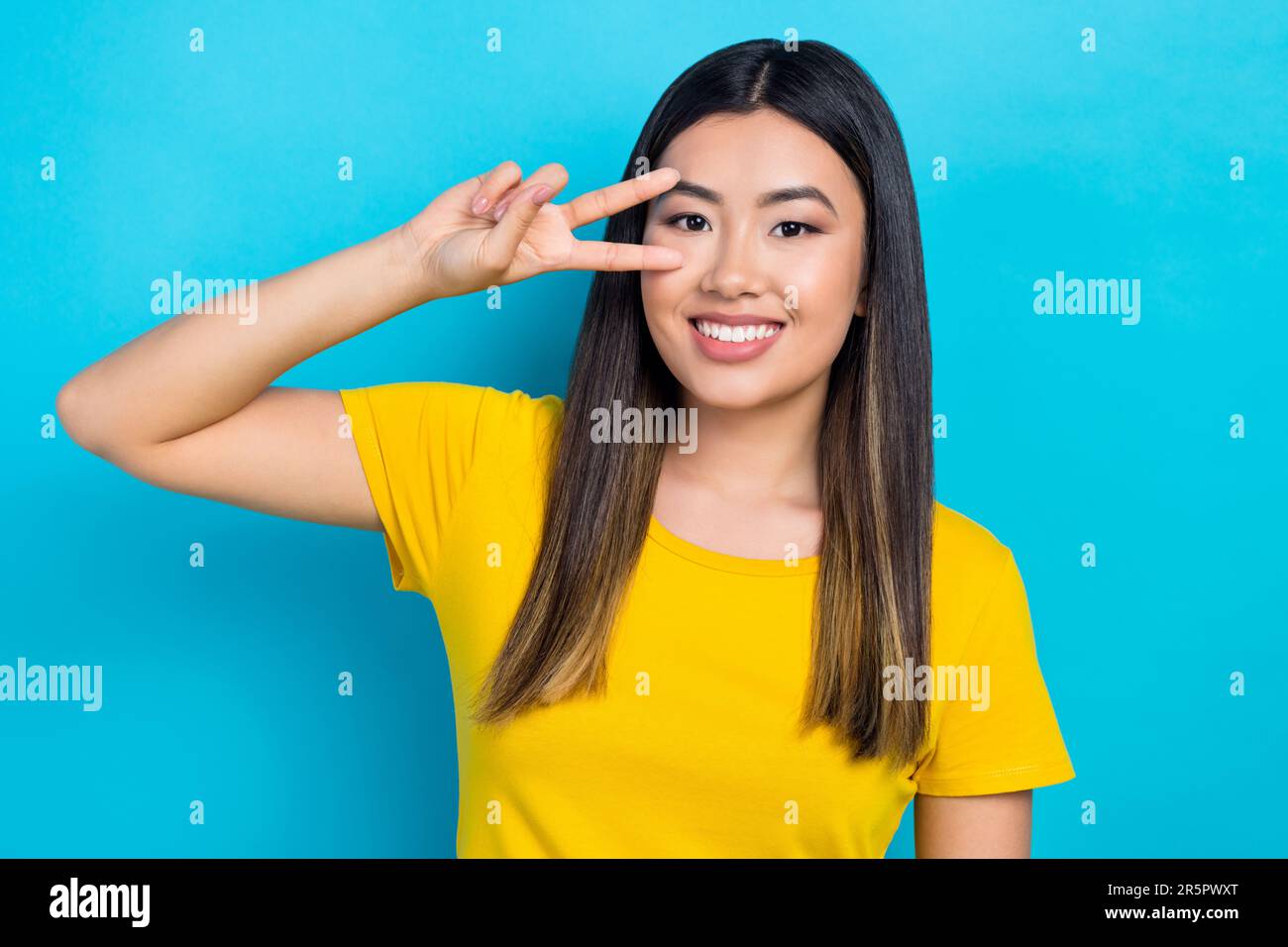 Portrait of cute pretty asian girl say hi show v sign gesture near eye ...