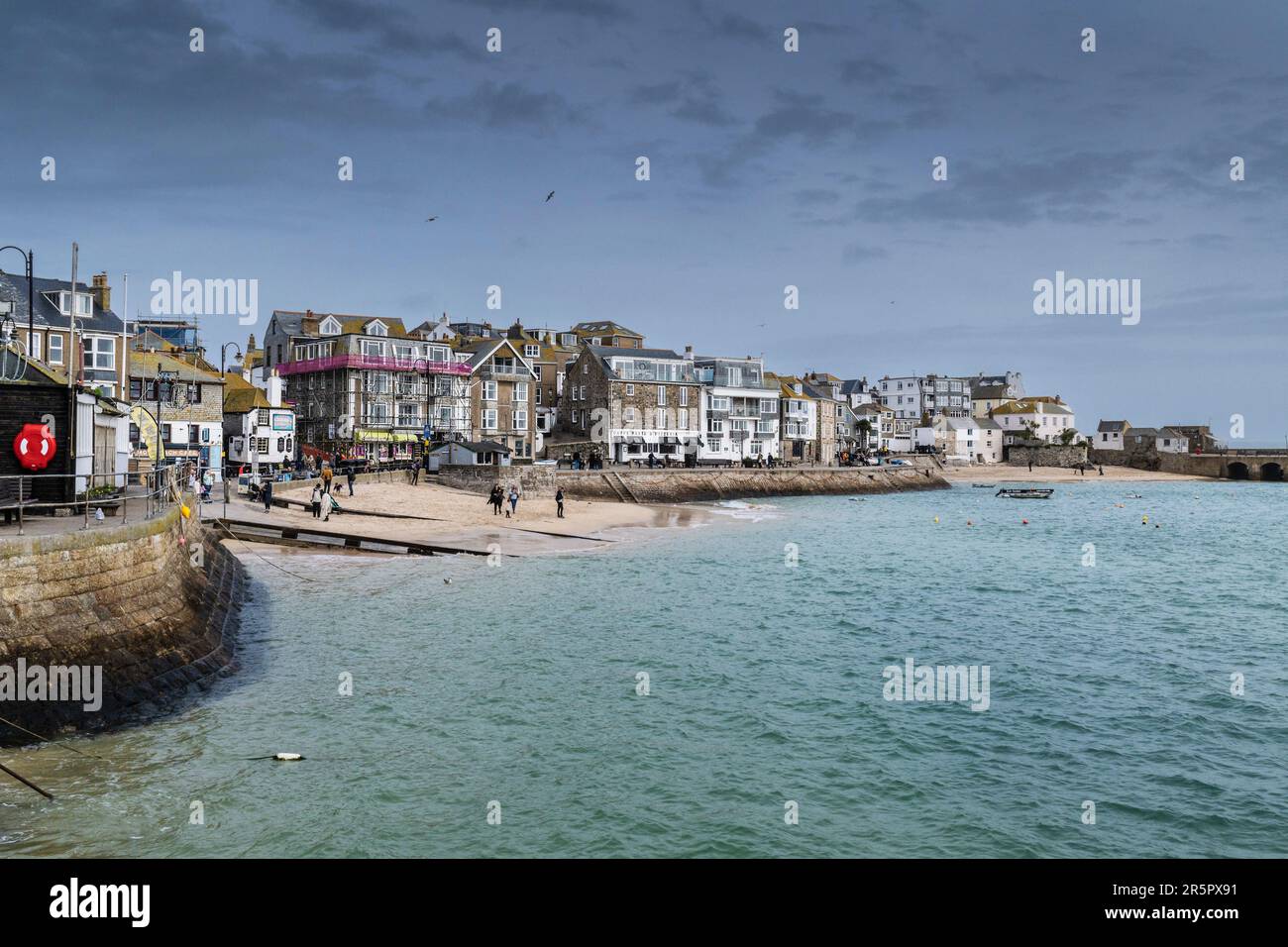 UK weather. Visitors on the beach on a rainy chilly miserable day in ...