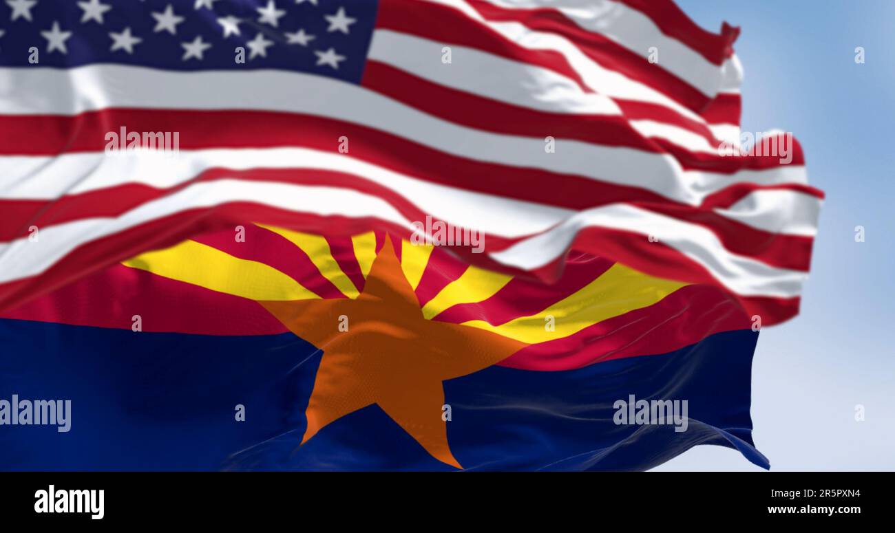 The flags of Arizona and United States waving in the wind on a clear ...