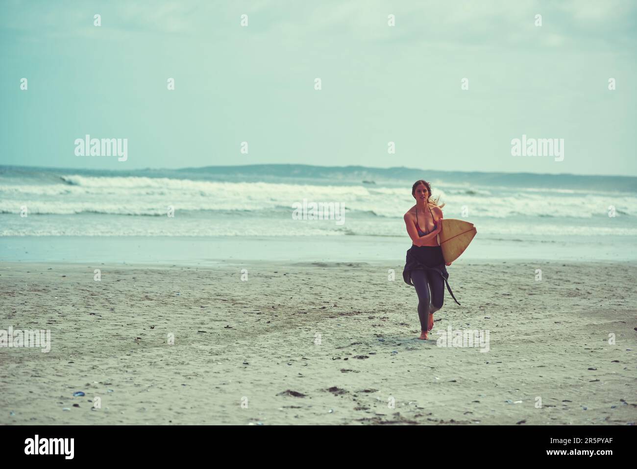 Kick off summer with a surf. a beautiful young woman going for a surf ...